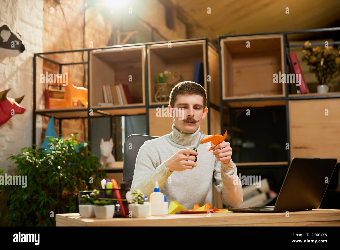 Making paper animal. Young man holds a master class on origami and ...