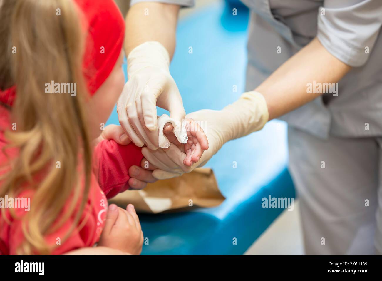 The hands of the doctor bandage the sore finger with a bandage of the ...