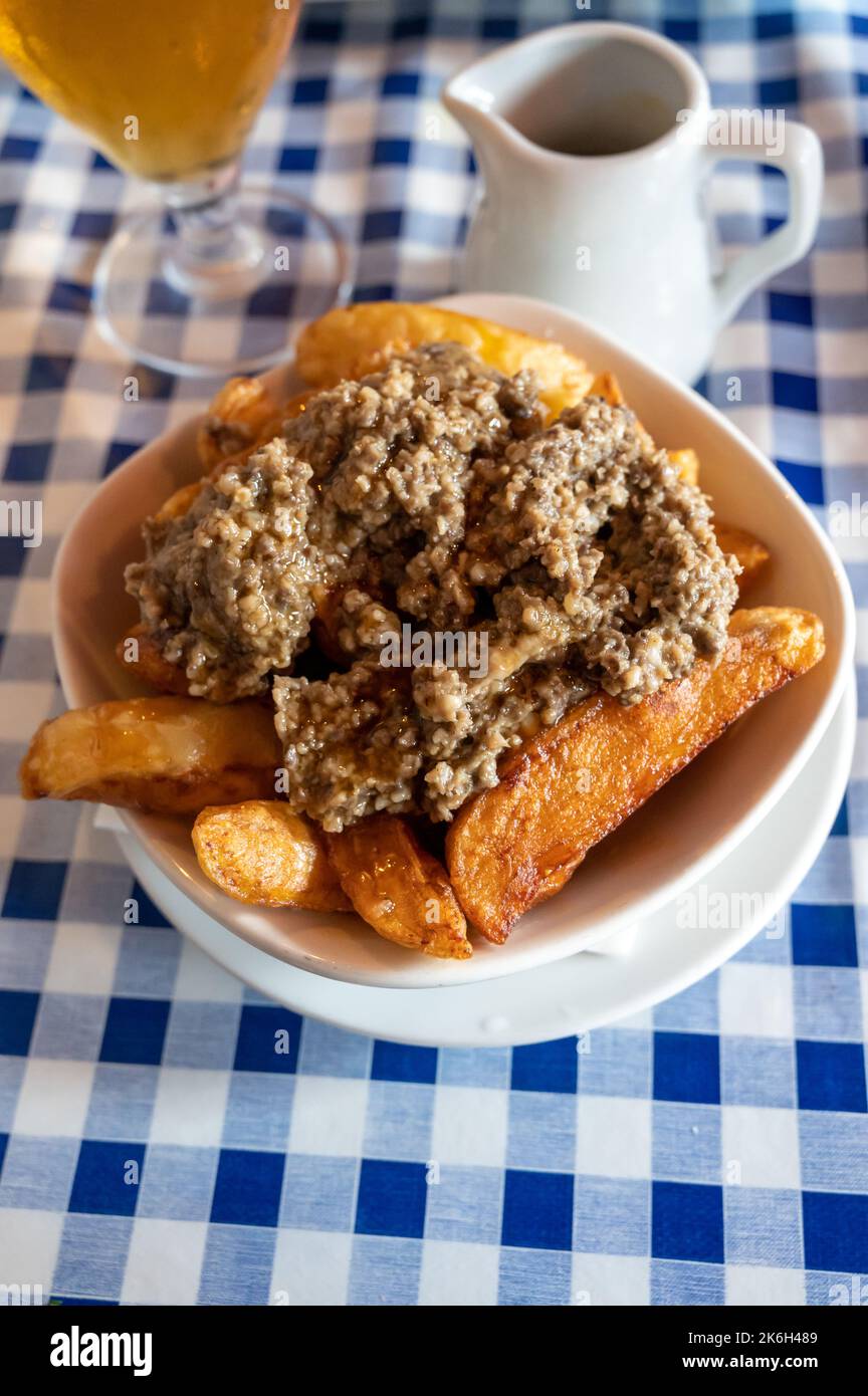 Scottish traditional snack food, hand cut potato chips topped with ...