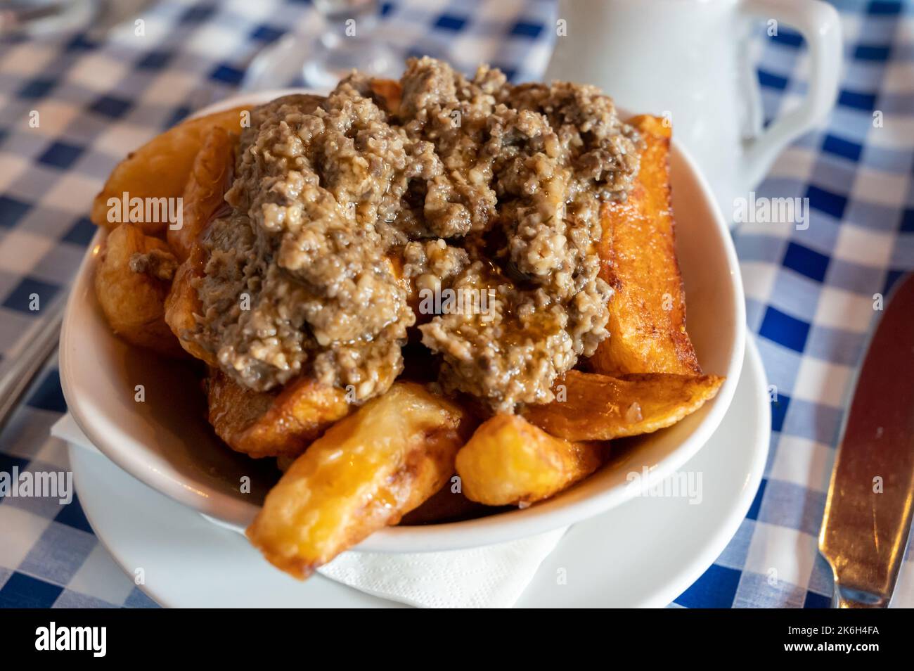 Scottish traditional snack food, hand cut potato chips topped with ...