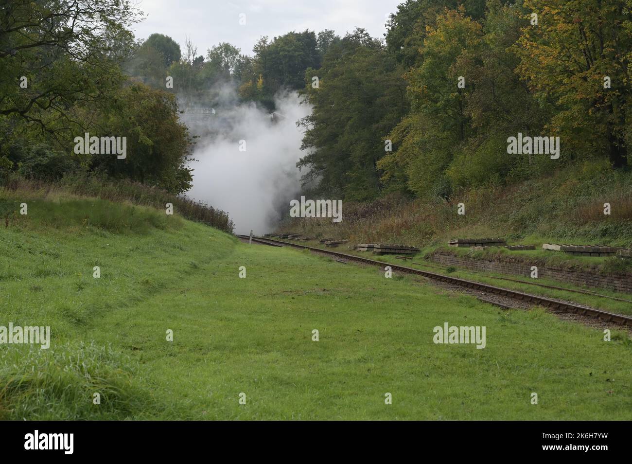 White smoke emerging from a tunnel after a steam locomotive has passed ...