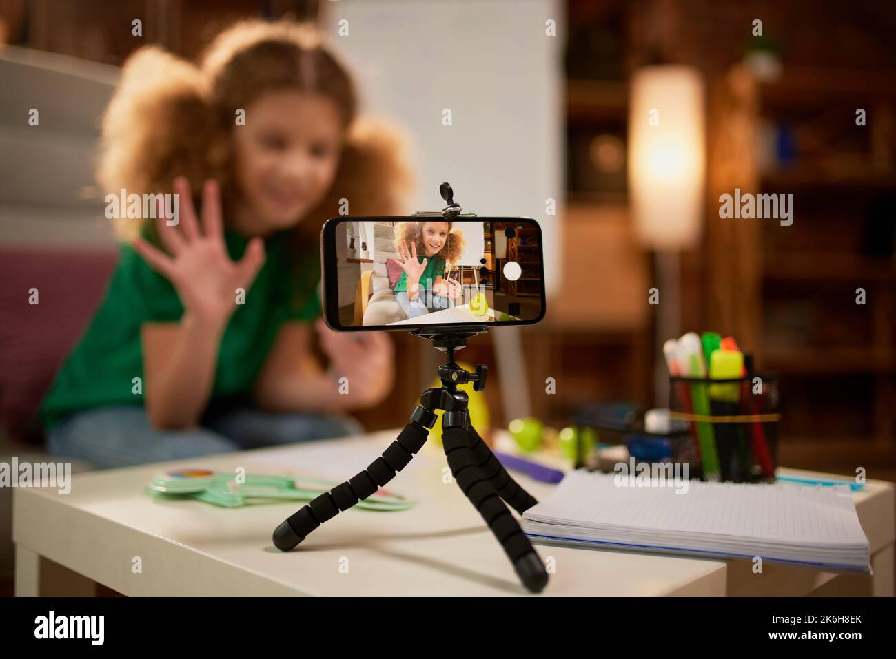 View through phone screen. Cute little elementary schoolgirl recording ...