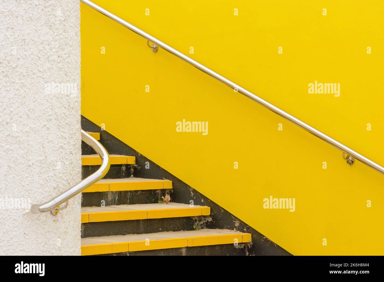 Yellow wall with steps and chrome handrail Stock Photo - Alamy