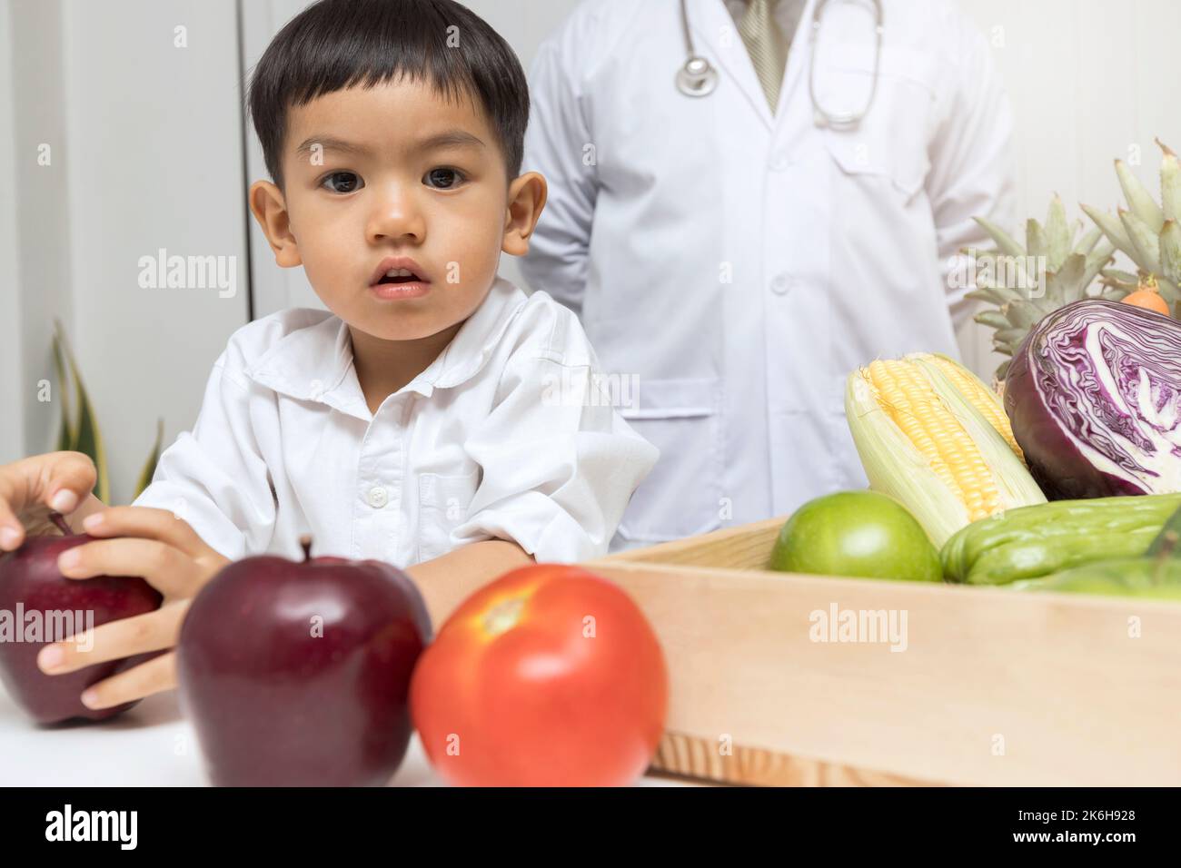 A boy and doctor happy to have healthy food. Kid learning about ...