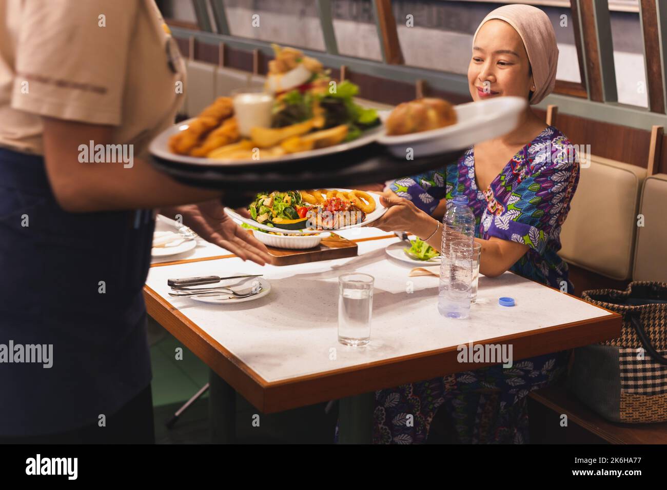 Happy woman customer with smile while getting food from waitress in ...