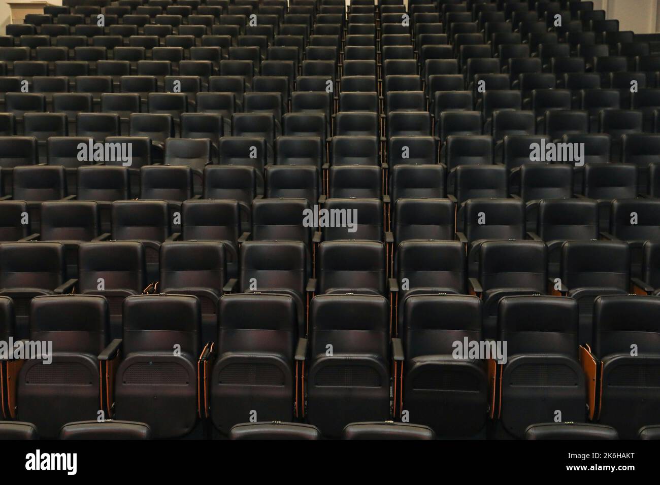 Theater auditorium with emphasis on the black chairs and wooden sides ...
