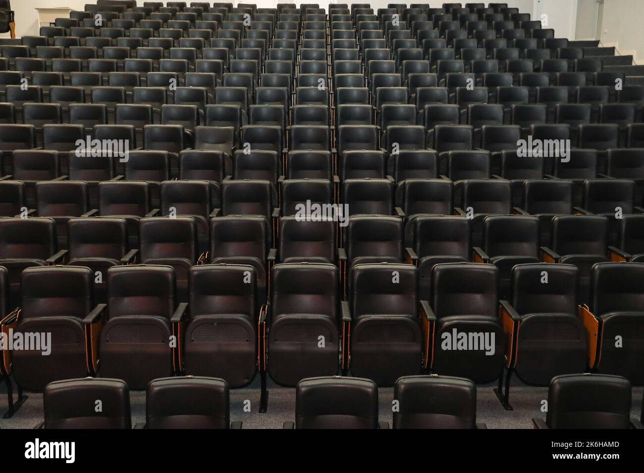 Theater auditorium with emphasis on the black chairs and wooden sides ...