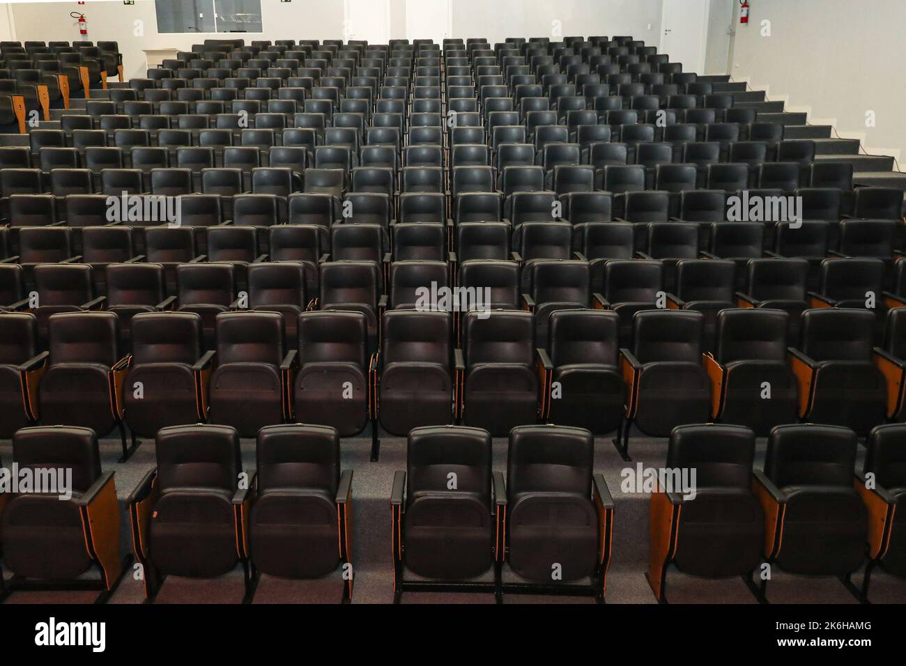 Theater auditorium with emphasis on the black chairs and wooden sides ...