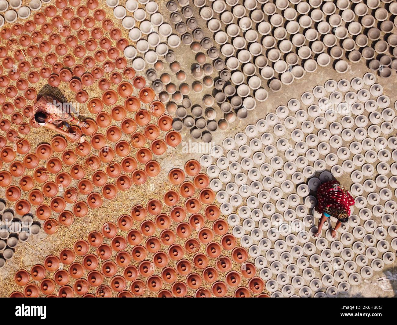 Workers make clay pots as a form of pottery business to sell at a ...