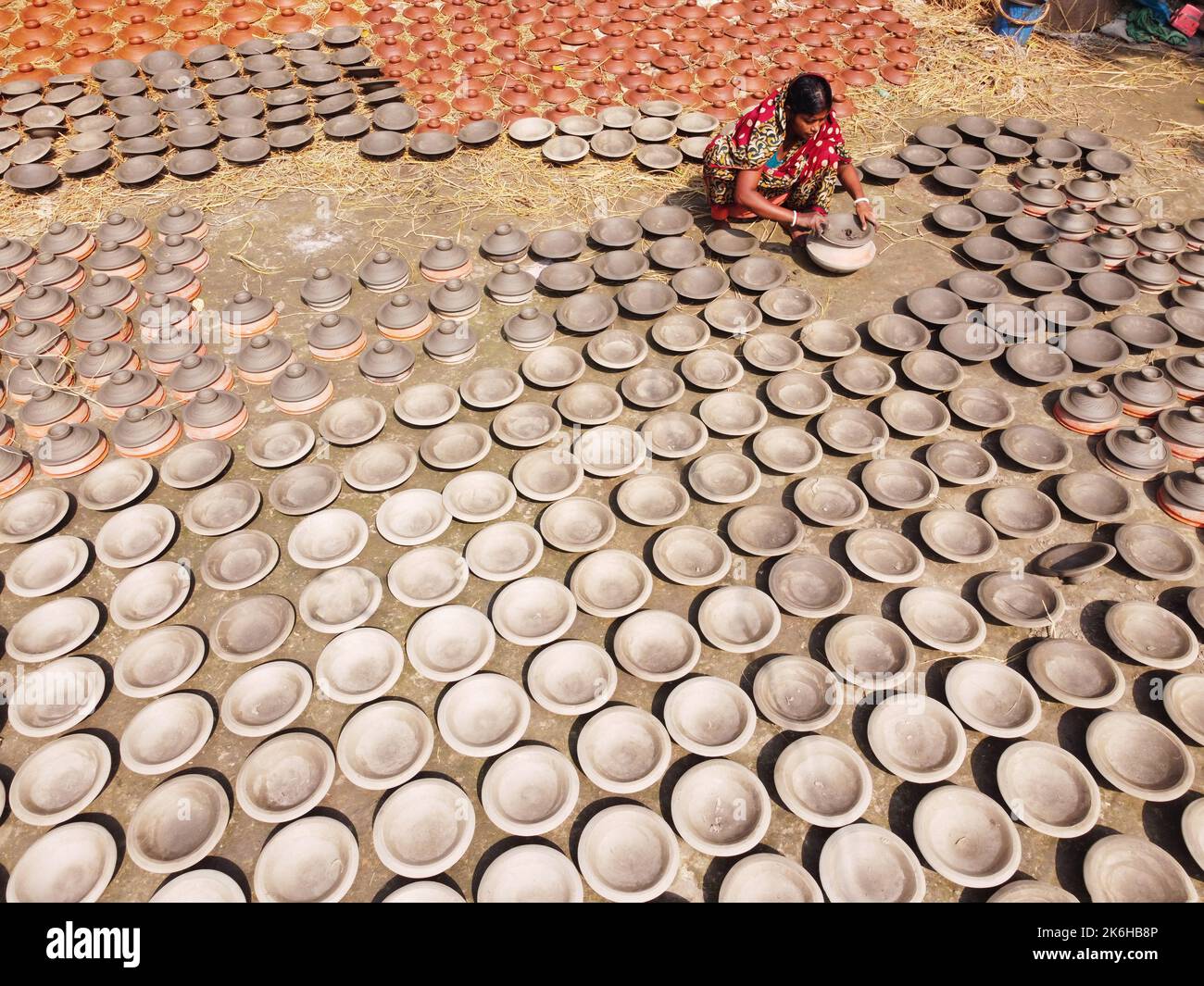 Workers make clay pots as a form of pottery business to sell at a ...