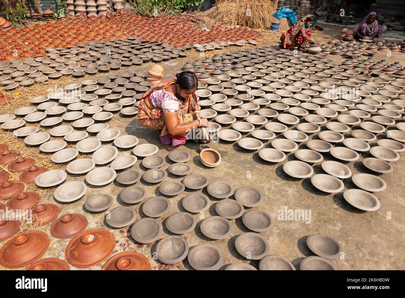 Workers make clay pots as a form of pottery business to sell at a ...