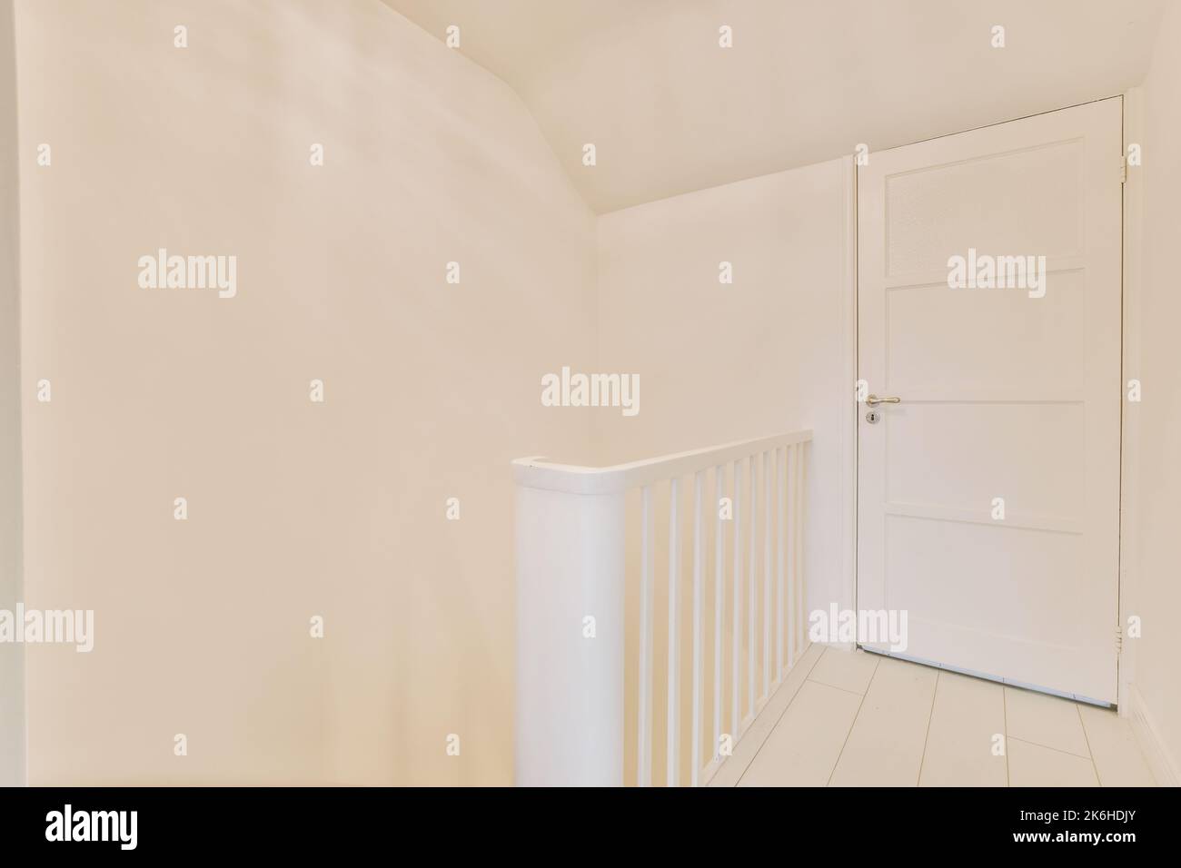 White door of room located near framed pictures and stylish lamp on top ...