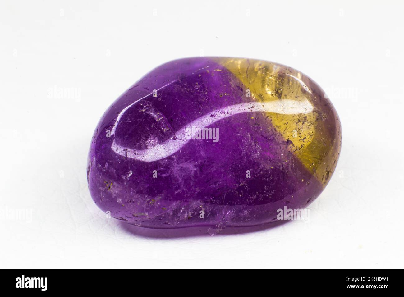 Real tumbled Ametrine stone macro isolated on white surface. Purple ...