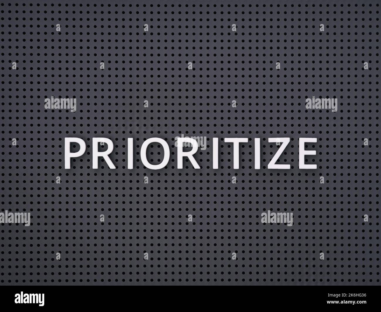 Word Prioritize spelled out with white letters on a gray pegboard Stock ...