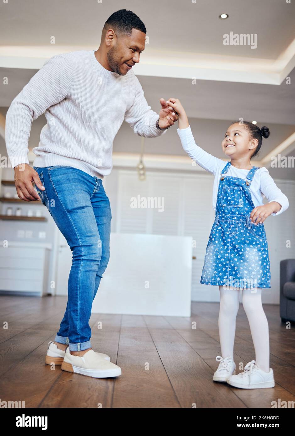 Handsome mixed race father dancing at home with his little girl. Happy ...