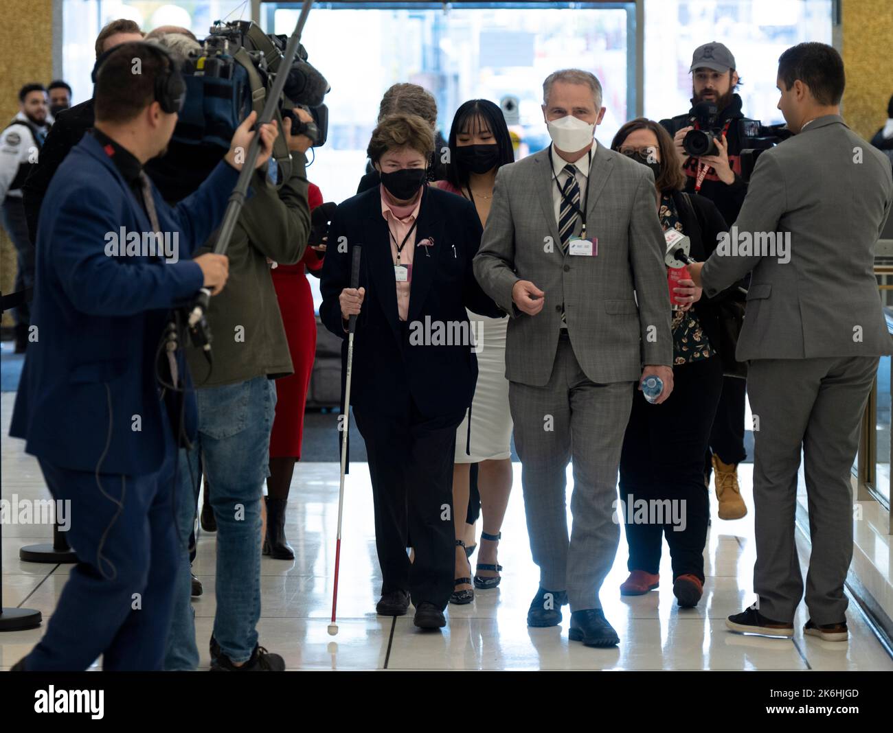 Media follow Victoria De La Ronde, centre, and Zexi Li, the first ...
