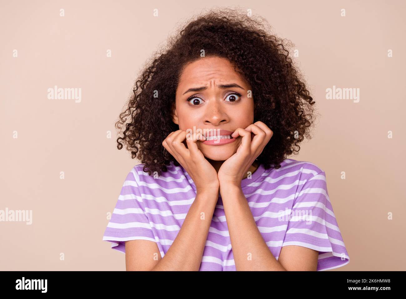 Photo of scared shocked lady wear violet t-shirt biting fingers ...
