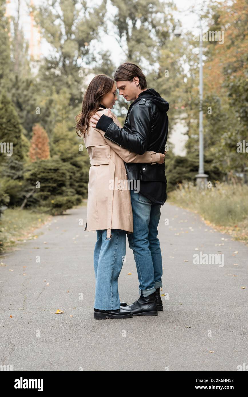 full length view of stylish young man hugging pretty girlfriend in ...