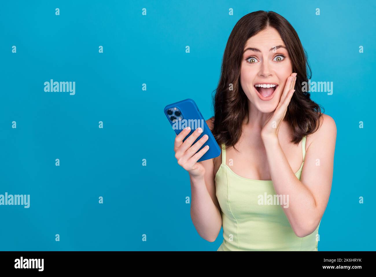 Photo of charming impressed lady wear green outfit arm cheek typing ...