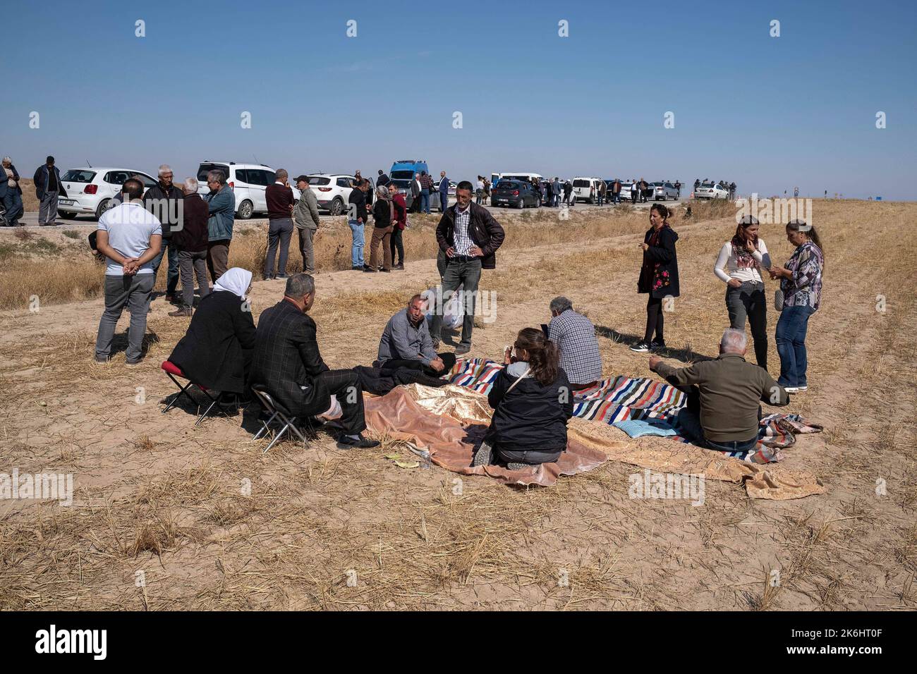 Mourners wait in the fields as they were blocked from going to the ...