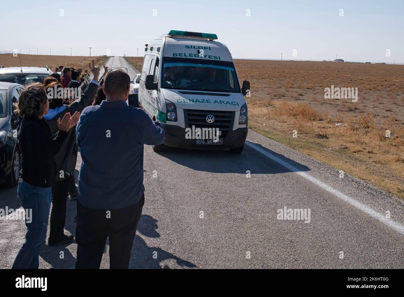 Mourners gather around the funeral vehicle as they were blocked from ...