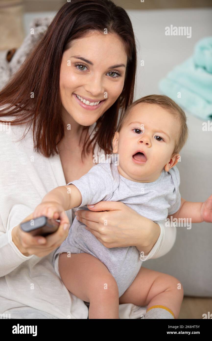young happy mother holding child with remote control Stock Photo - Alamy