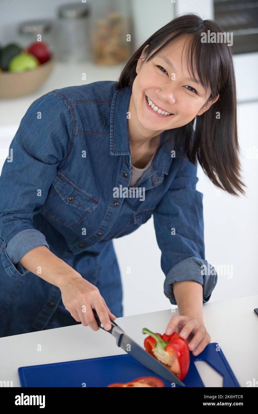 happy asian woman chopping peppers Stock Photo - Alamy