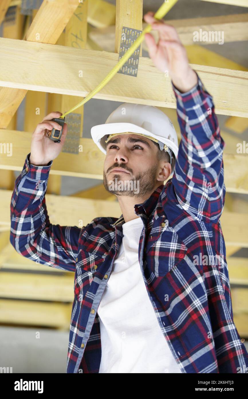 a builder measuring roof truss Stock Photo - Alamy