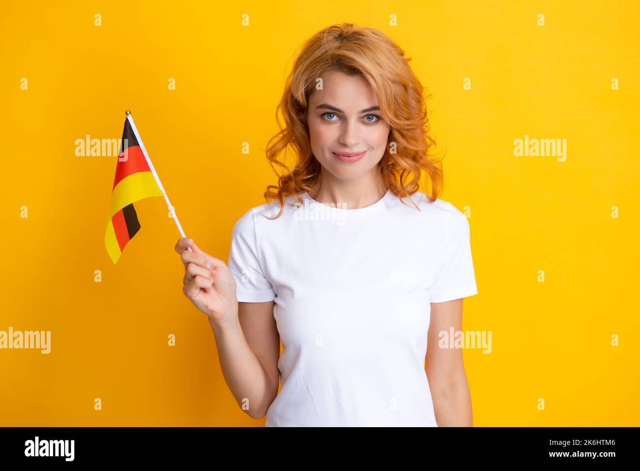 Portrait of positive student woman holding German flag. Isolated on ... Portrait of positive student woman holding German flag. Isolated on ...