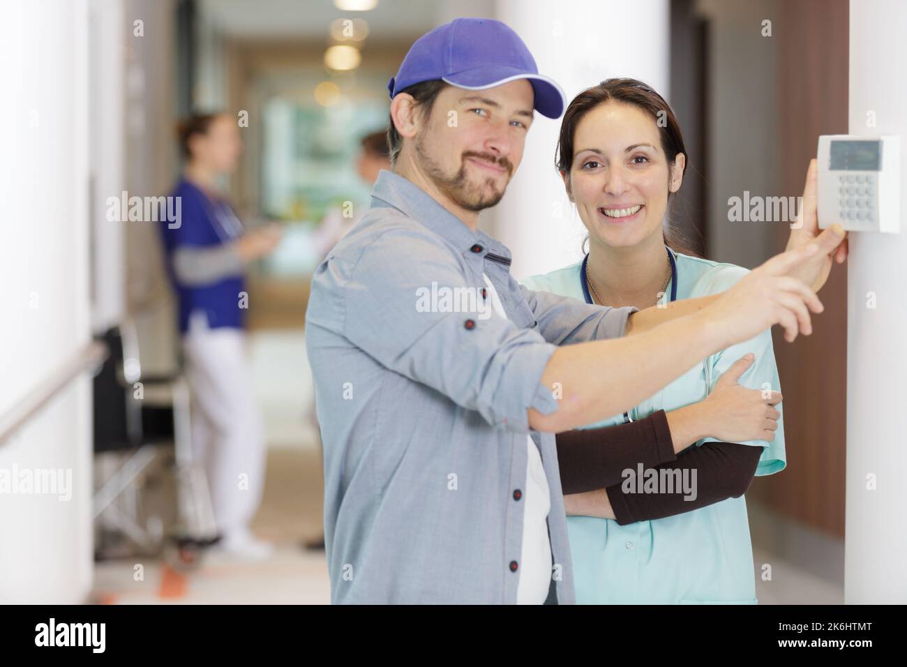 nurse with contractor installing keypad in hospital Stock Photo - Alamy