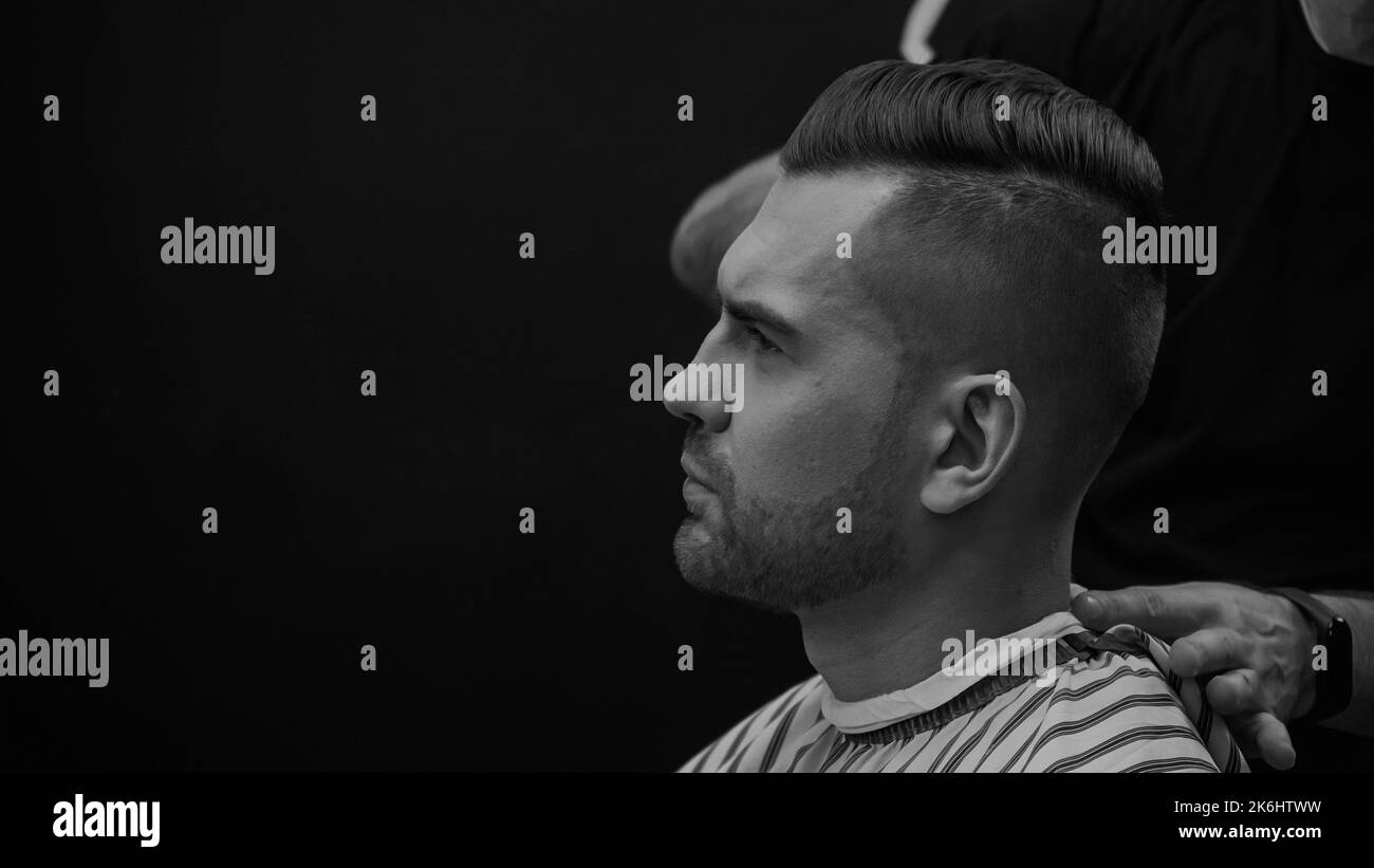 Barber wearing hairdressing cape on client in barbershop,stock image ...