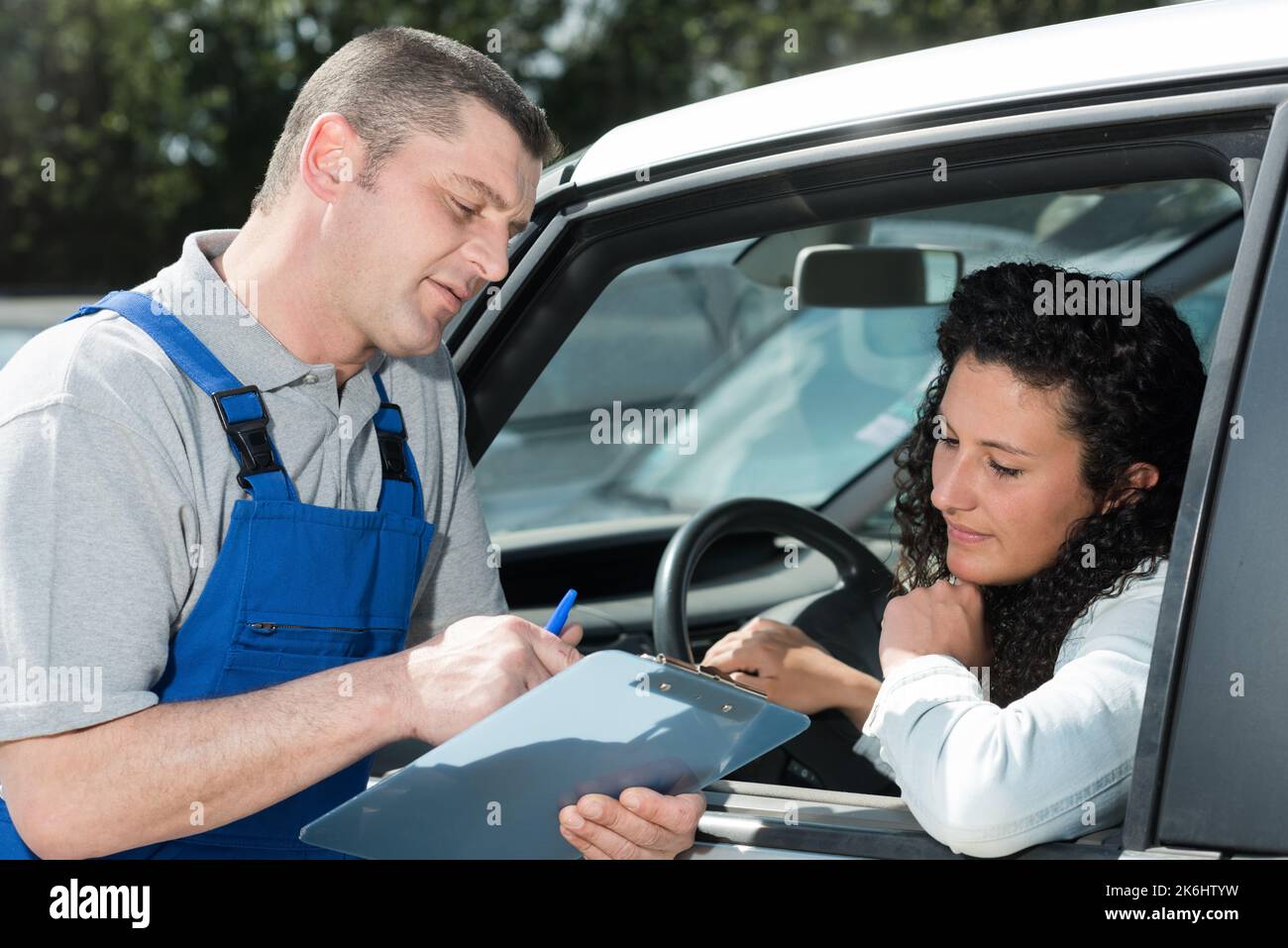 auto mechanic and customer smiling in auto repair shop Stock Photo - Alamy