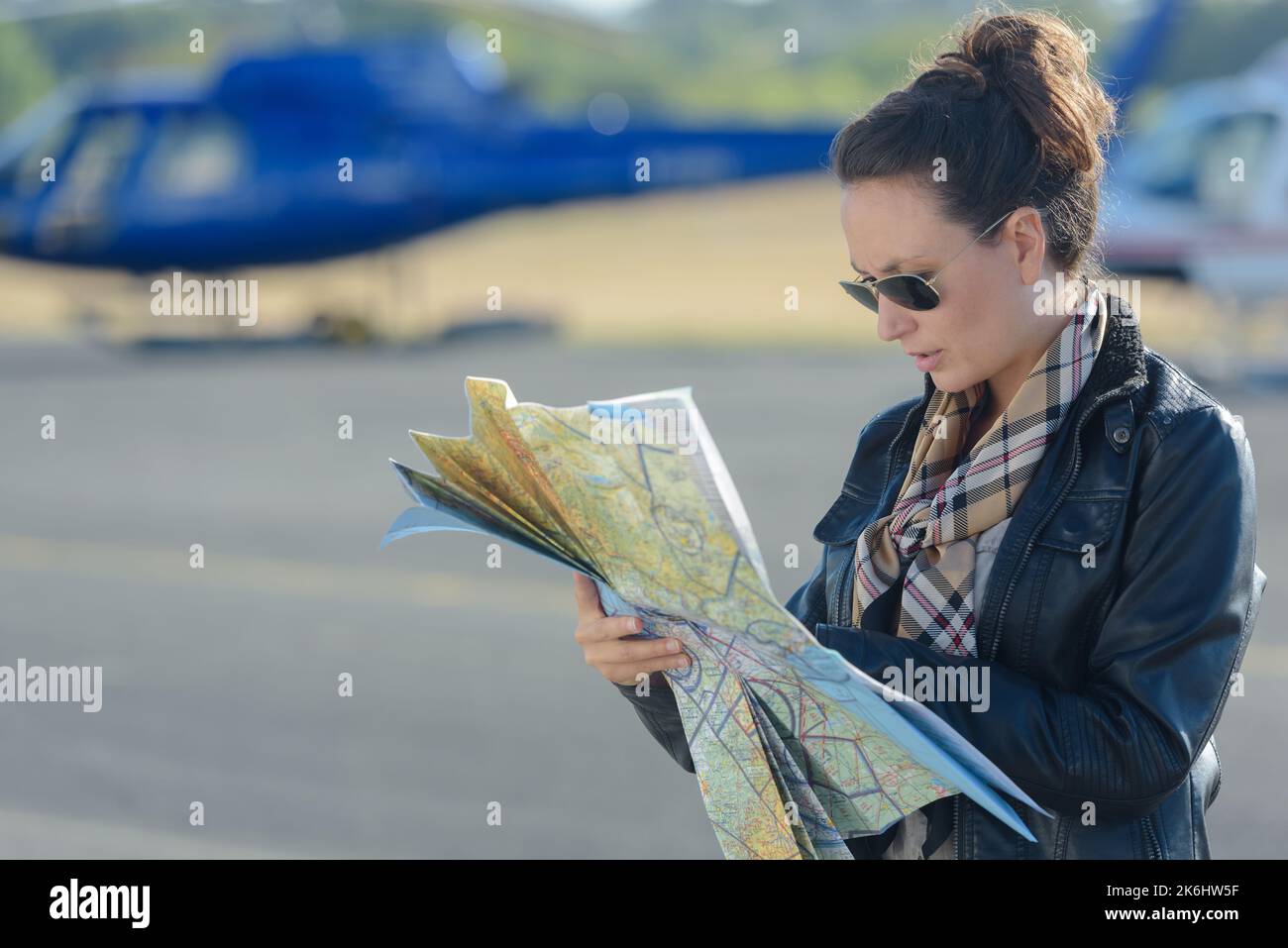 young woman helicopter pilot studying map before flight Stock Photo - Alamy