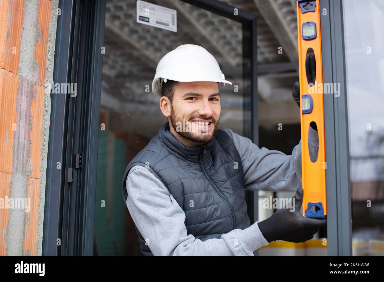 a carpenter installs a window in a low energy house Stock Photo - Alamy