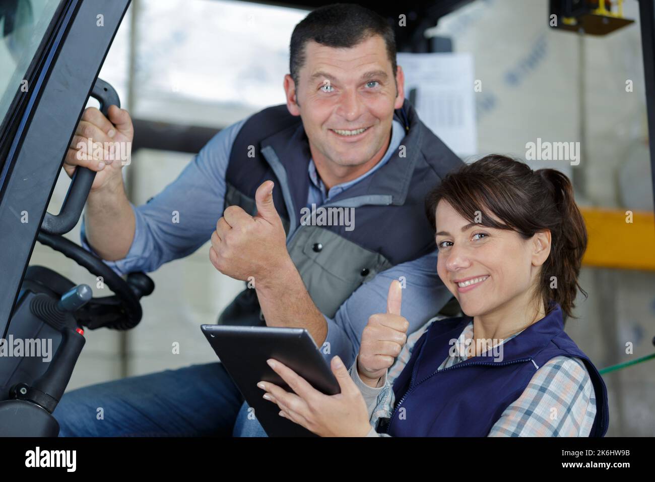forklift driver and female supervisor showing thumbs up Stock Photo - Alamy