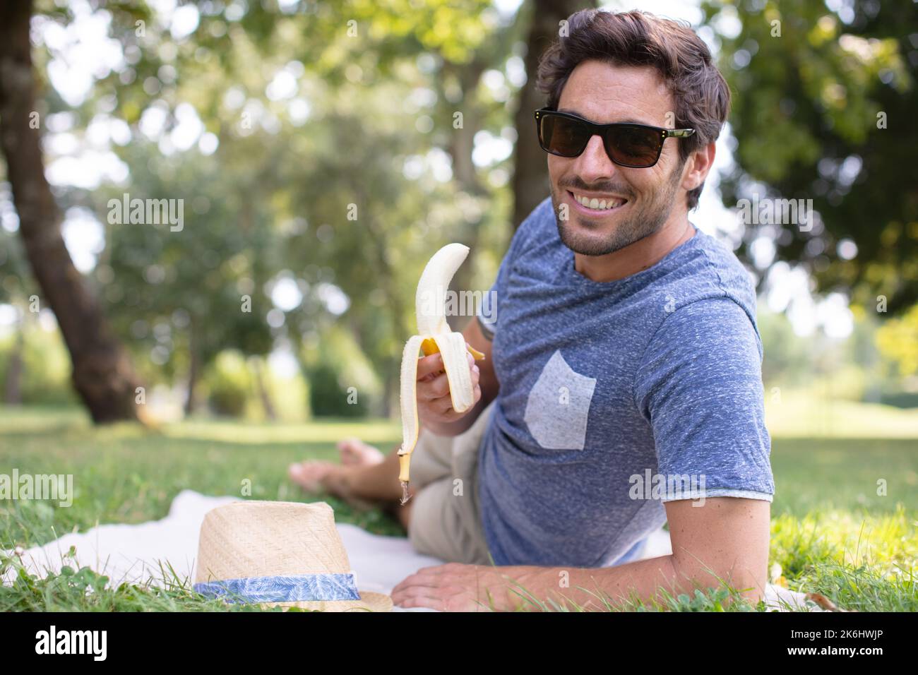 handsome man eating banana outdoors Stock Photo - Alamy