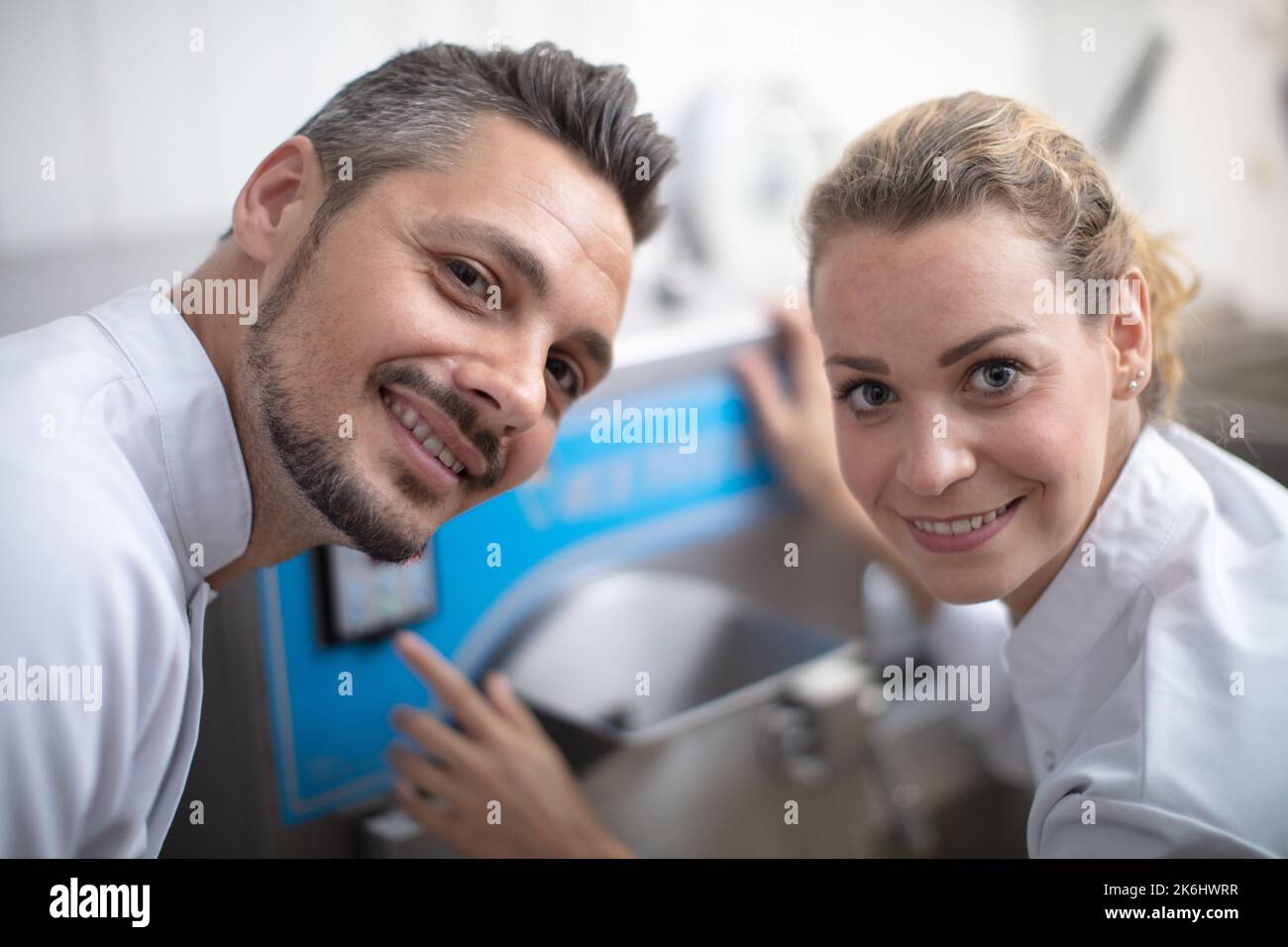 two smiling factory workers stood in a food factory Stock Photo - Alamy