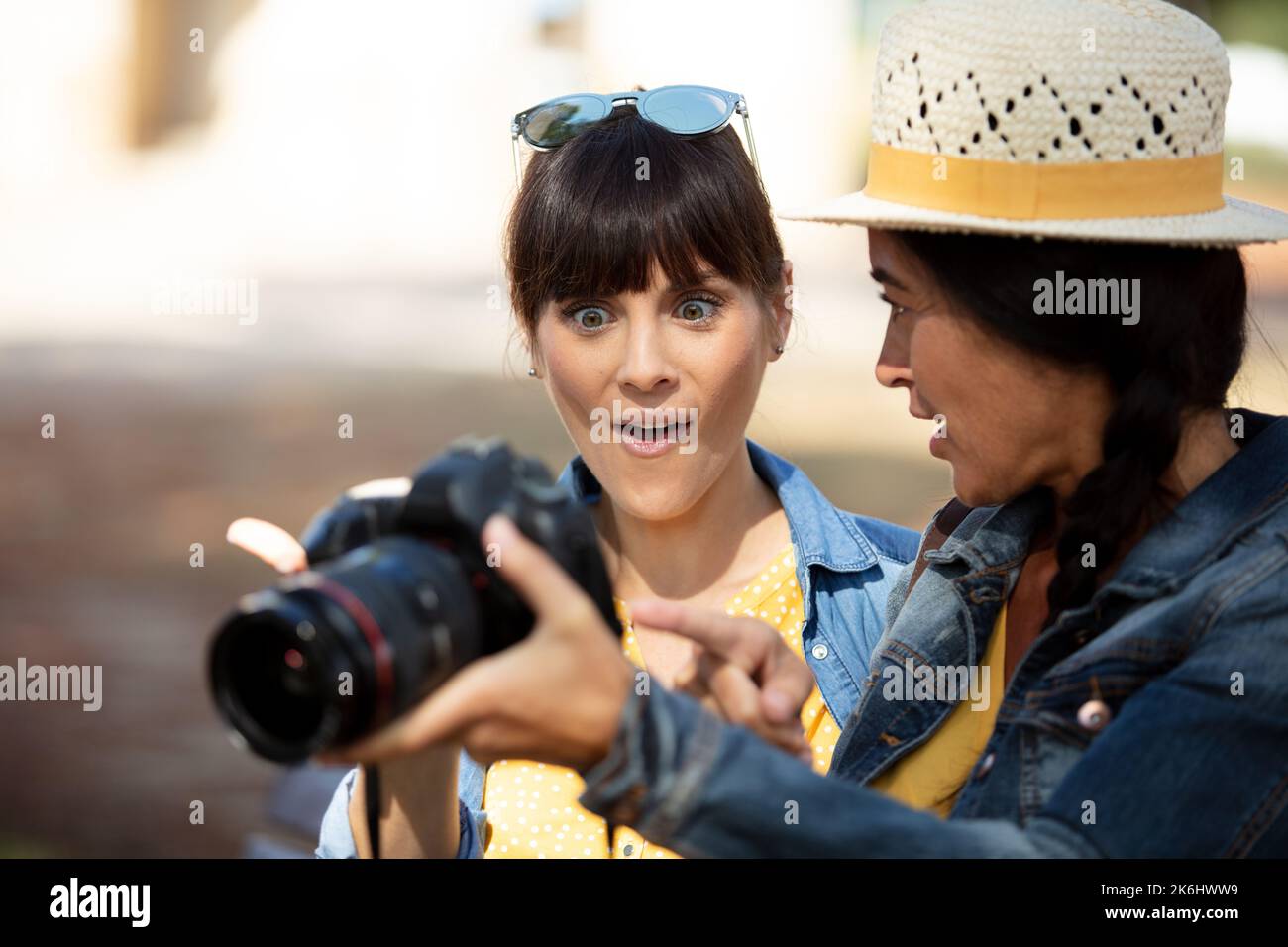 two tourists watching photos from a dslr camera Stock Photo - Alamy