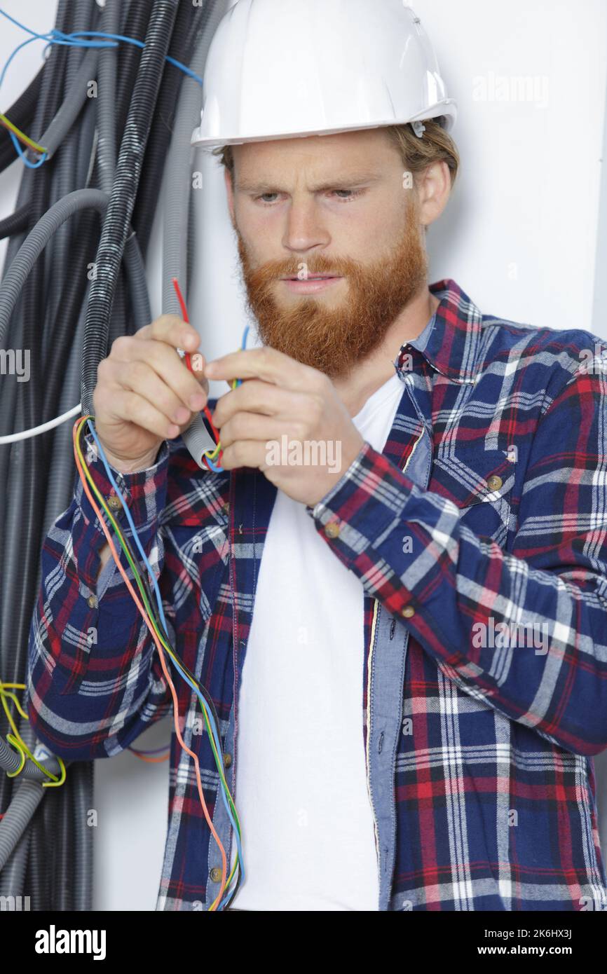 electrician engineer tests electrical installations and wires on relay ...
