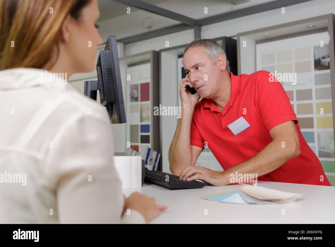 man seller wearing uniform checking paint on the phone Stock Photo - Alamy