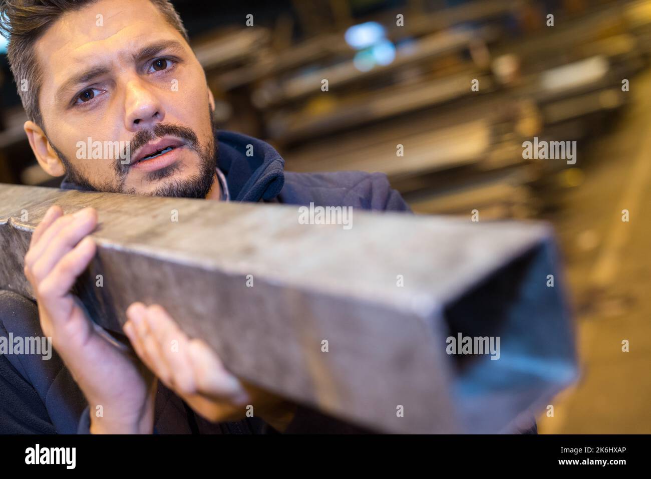 construction worker carrying reinforcement rods Stock Photo - Alamy