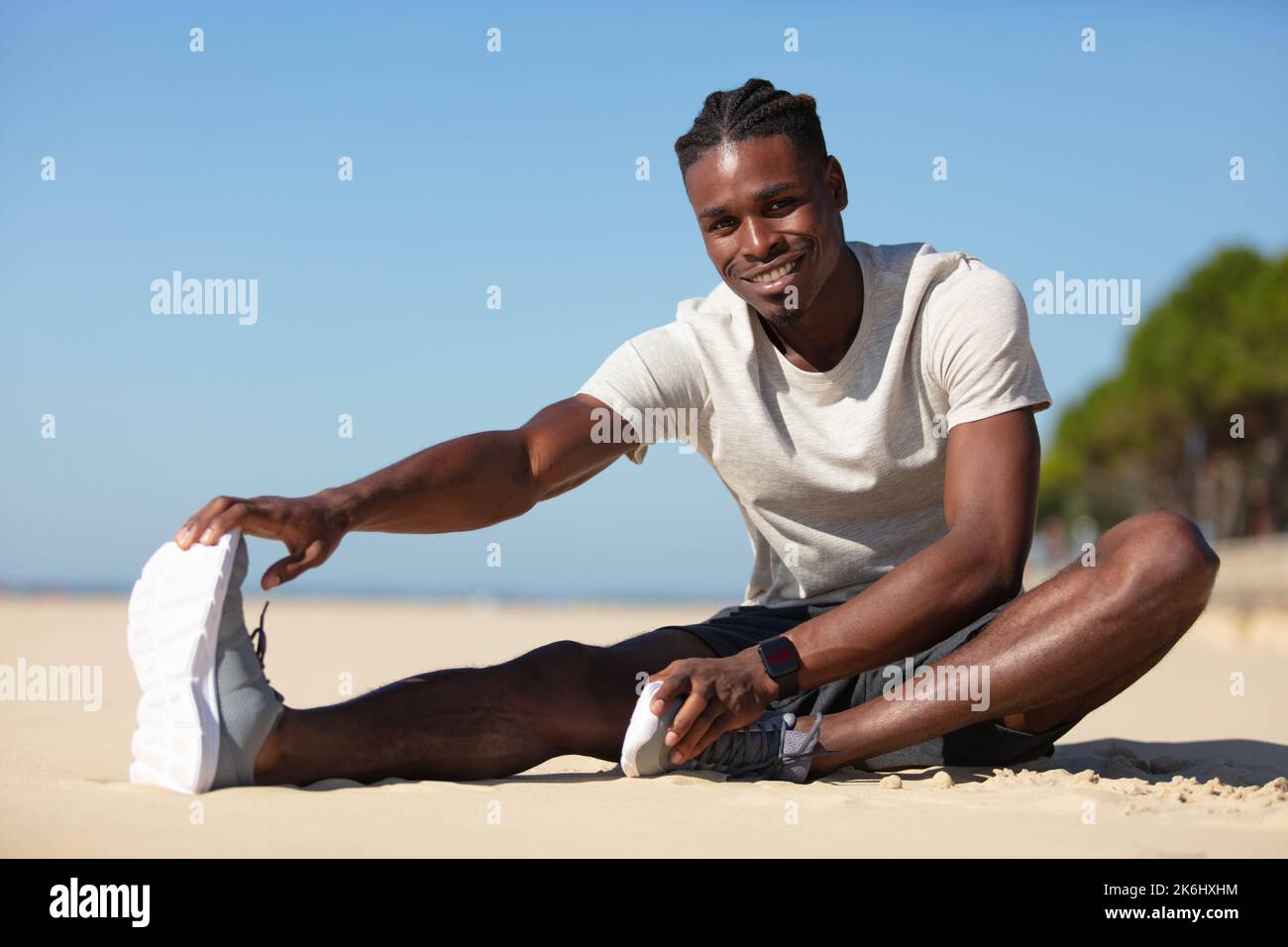 healthy young man warming up on the beach Stock Photo - Alamy