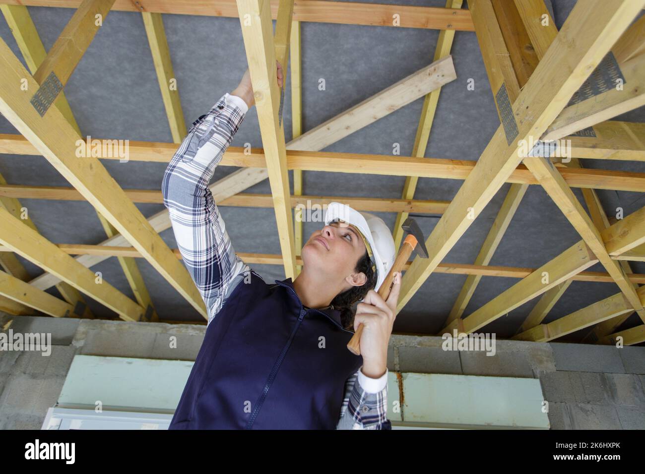 female worker hammering beams of the ceiling Stock Photo - Alamy
