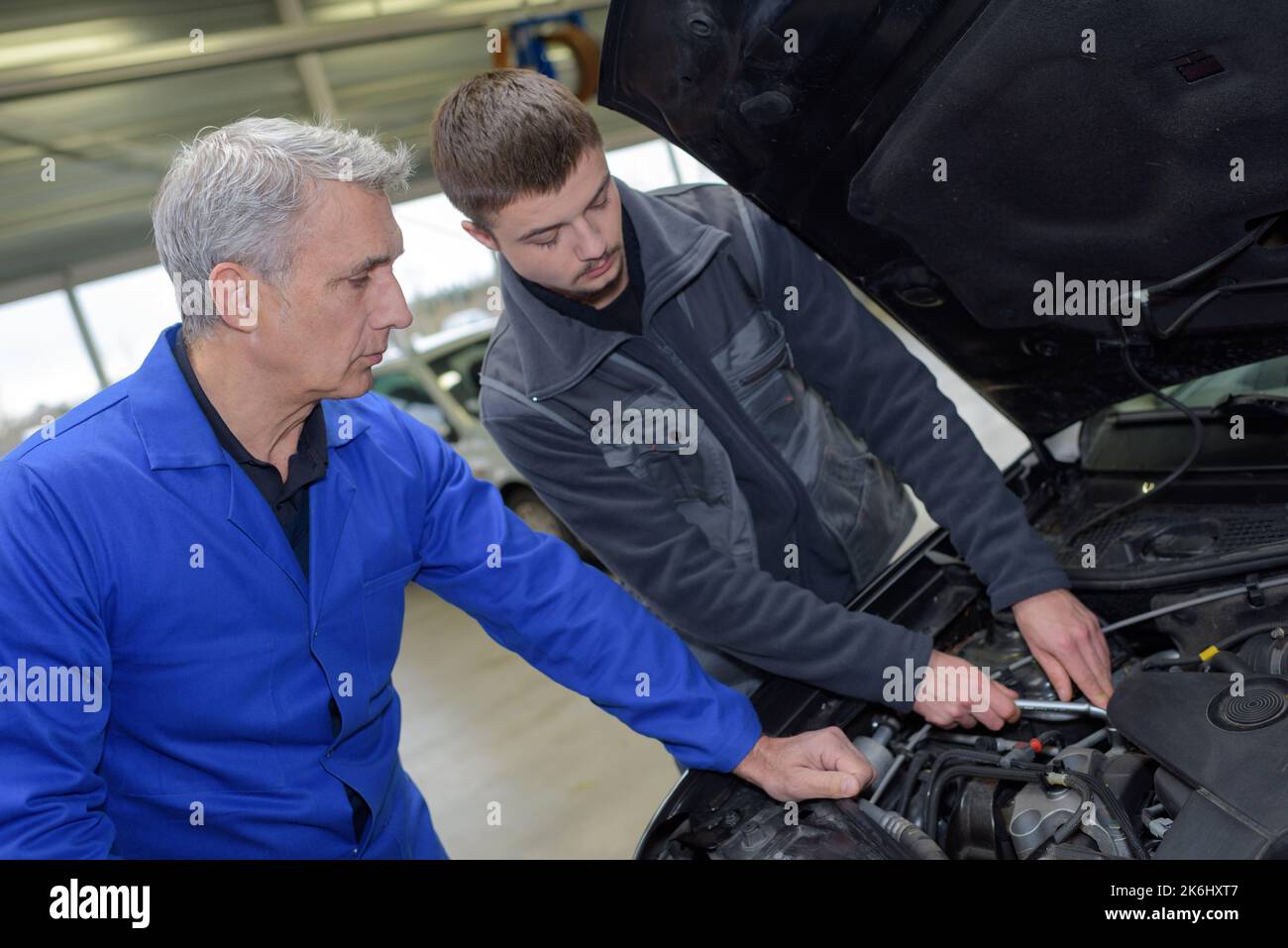 student with instructor repairing a car during apprenticeship Stock ...