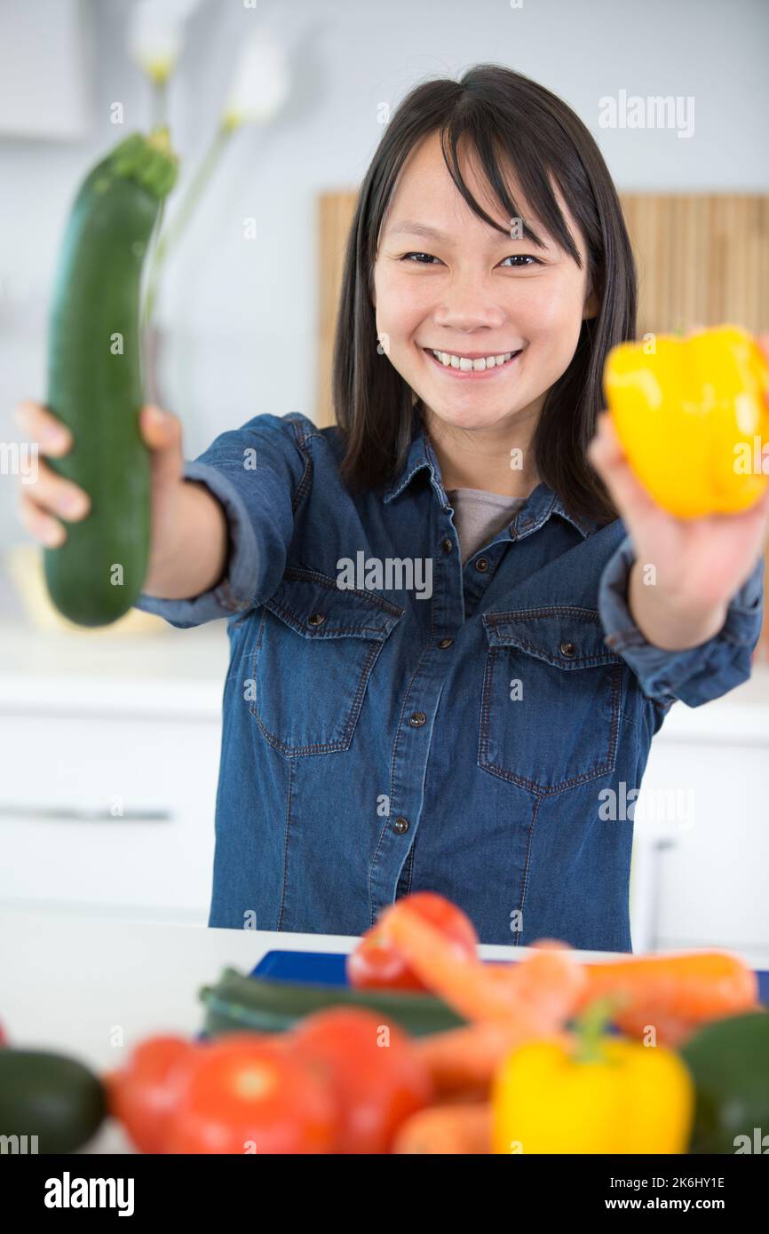 healthy asian woman showing vegetables in her kitchen Stock Photo - Alamy