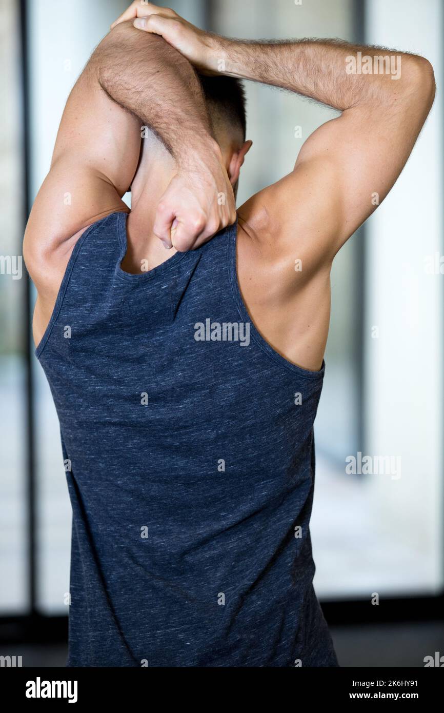 caucasian muscular man doing arm stretches at the gym Stock Photo - Alamy