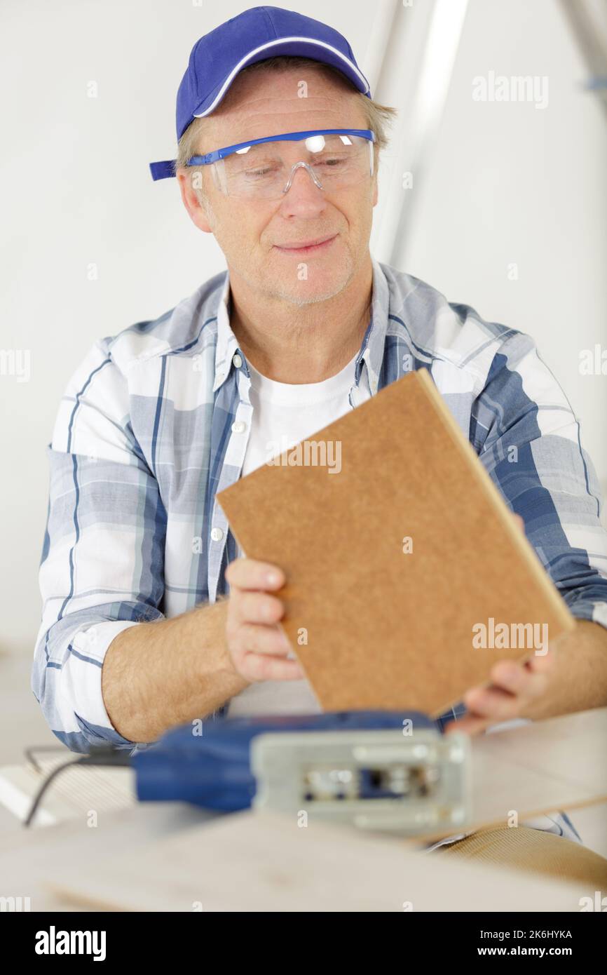 carpenter checking the sharp edges of a wood piece Stock Photo - Alamy