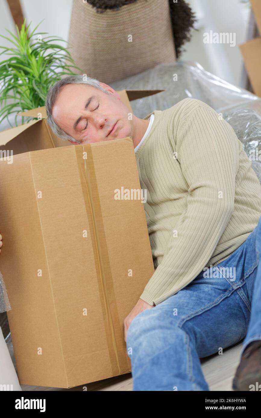 tired man sleeping on cardboard boxes around Stock Photo - Alamy