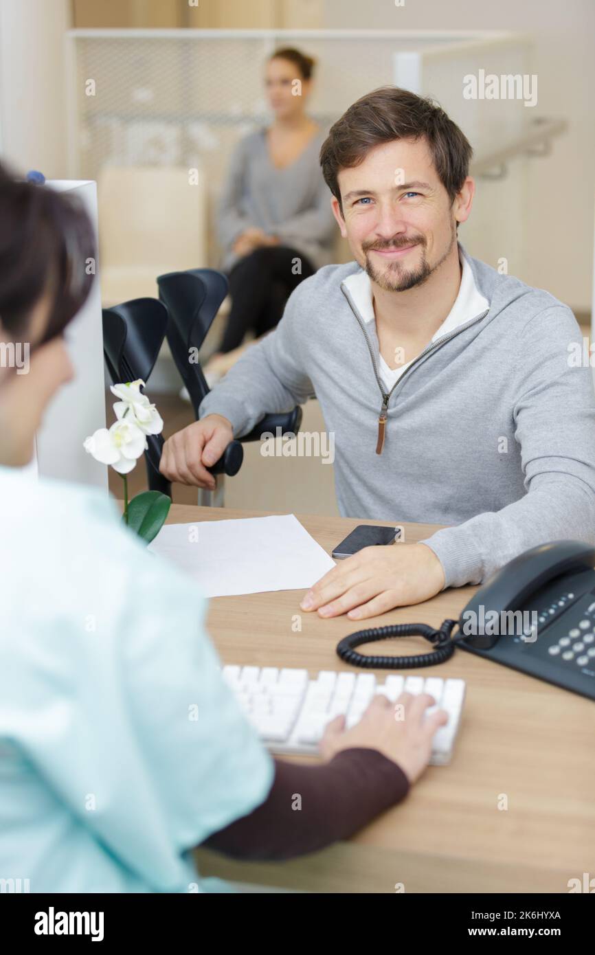 patient with wheelchair talking with a receptionist in a hospital Stock ...