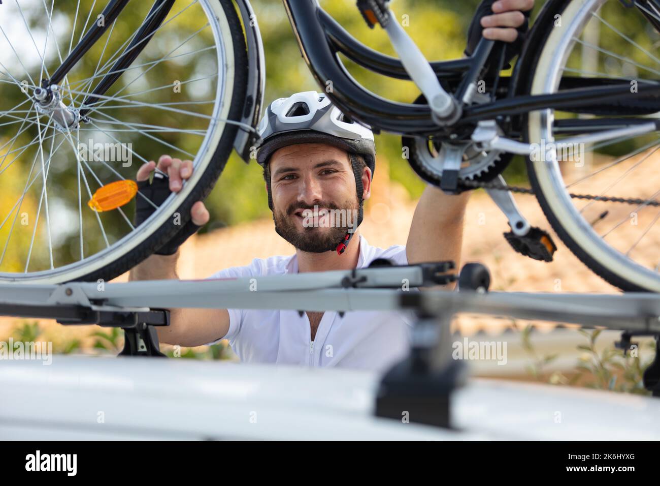 mountain biker man takes his bike from the car roof Stock Photo - Alamy